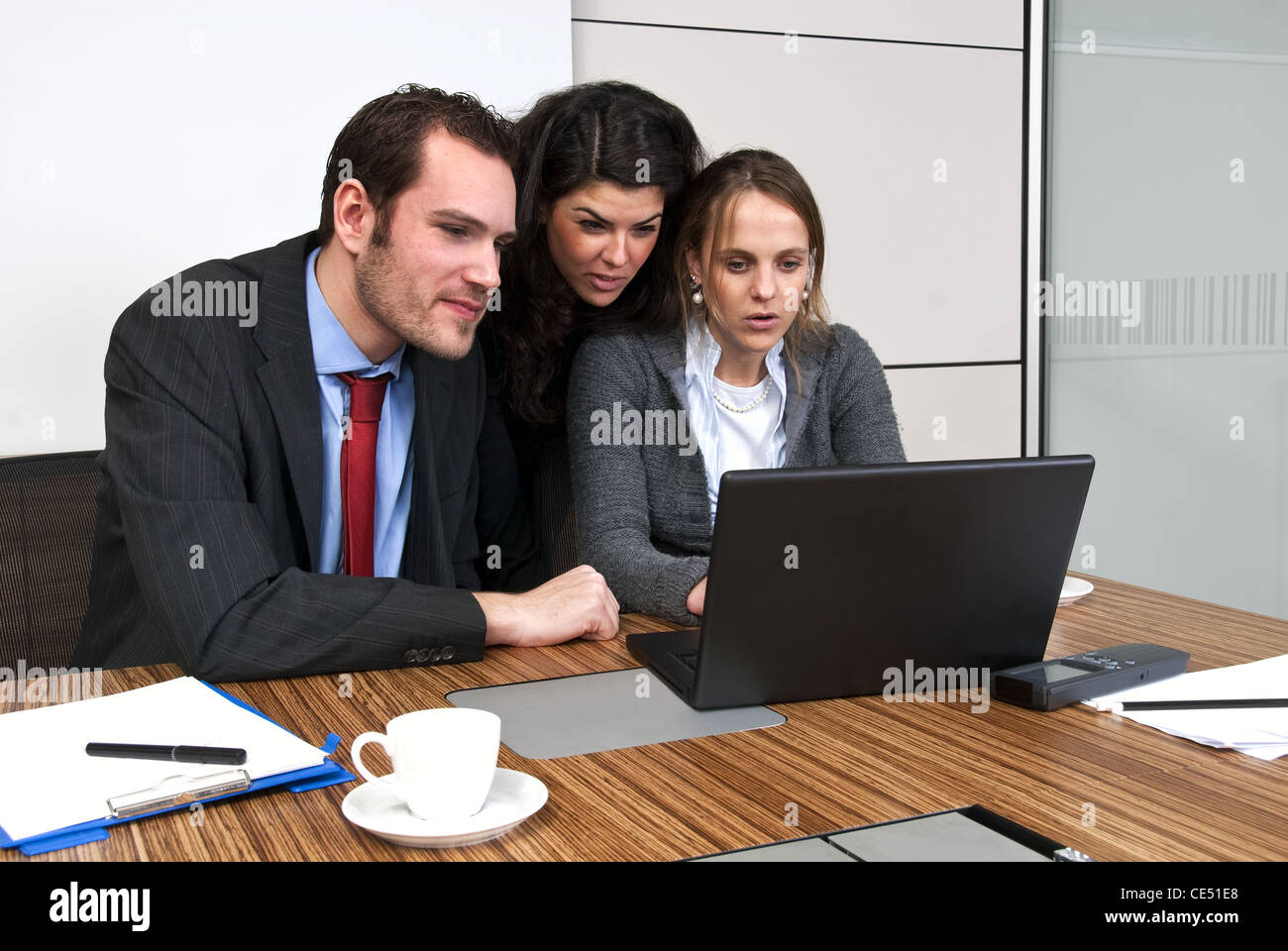 Three young staff members discussing business matters in a modern ...
