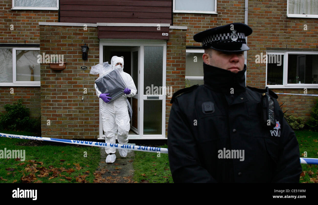 Scene Of Crime Officers remove a computer from a crime scene as a ...