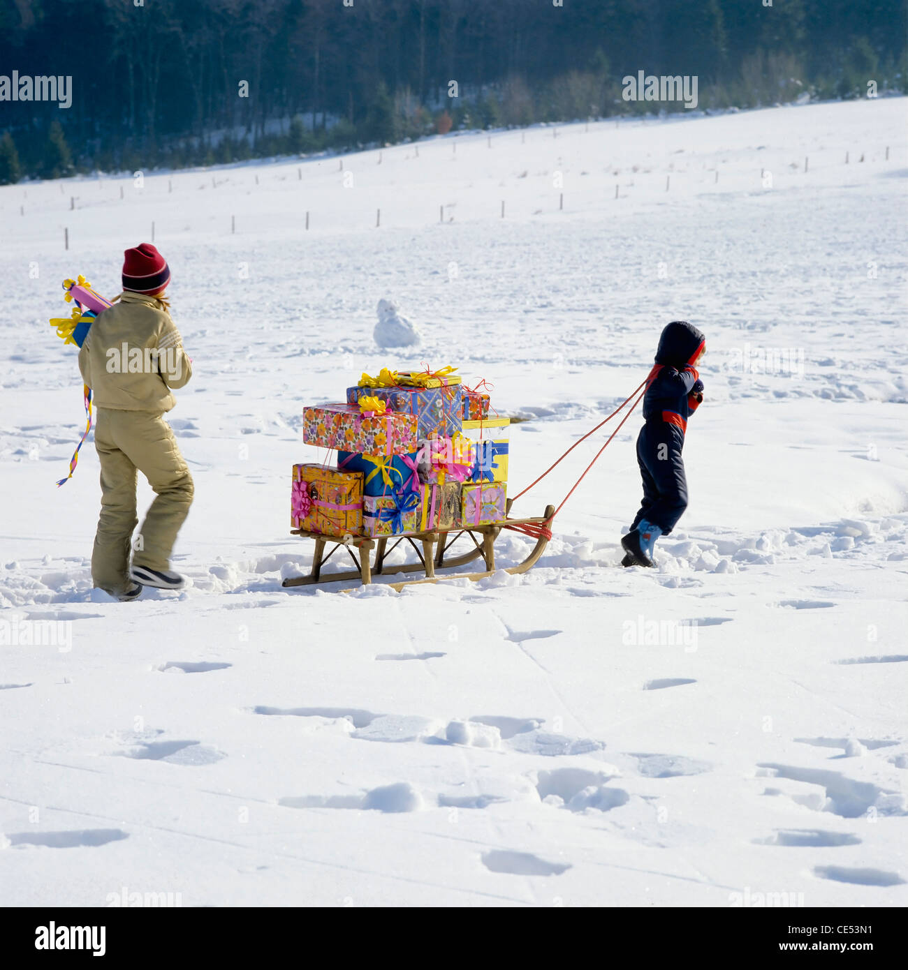 Two children pulling sledges hi-res stock photography and images - Alamy