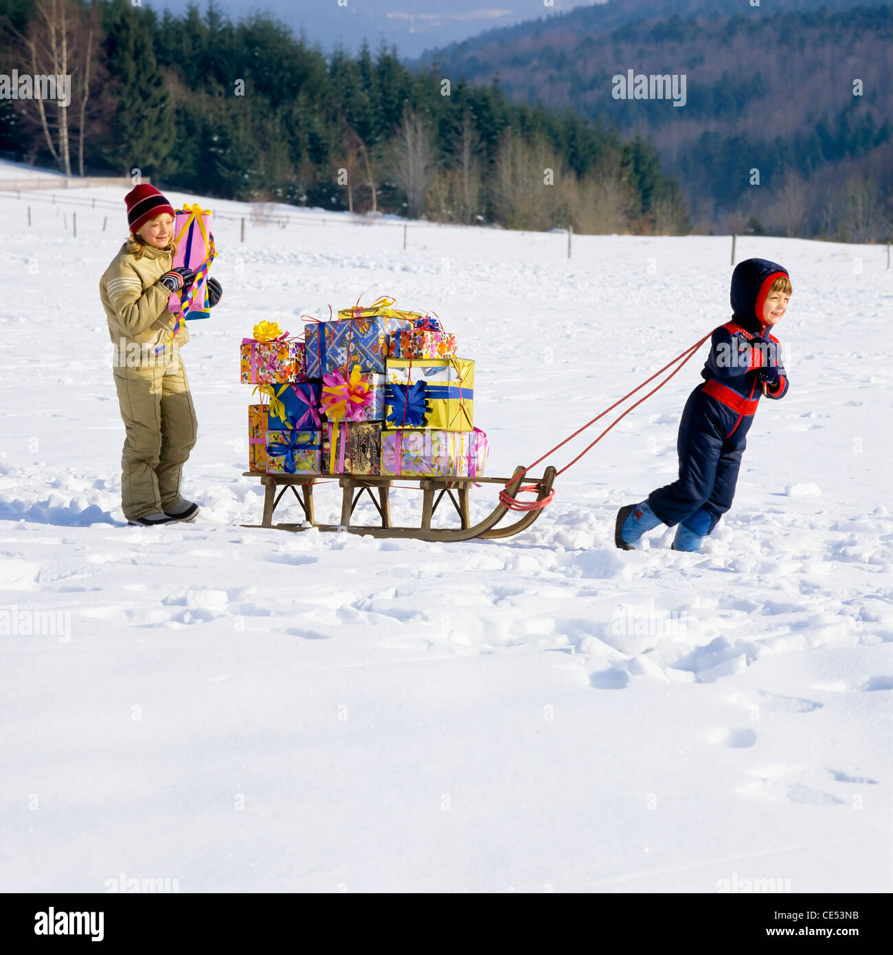 Two children pulling sledges hi-res stock photography and images - Alamy
