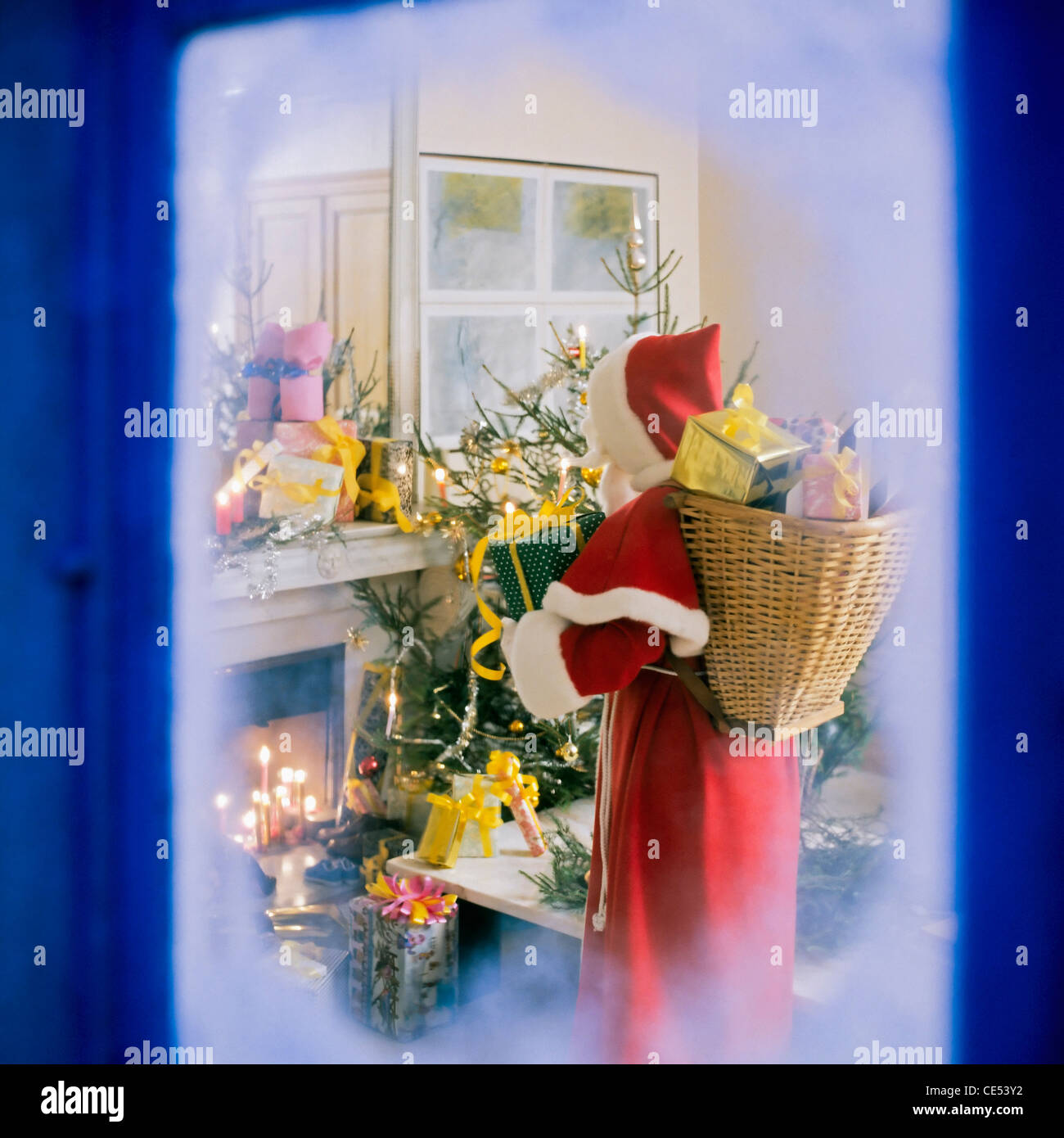 Santa Claus with Christmas presents seen through frosted window, Alsace ...