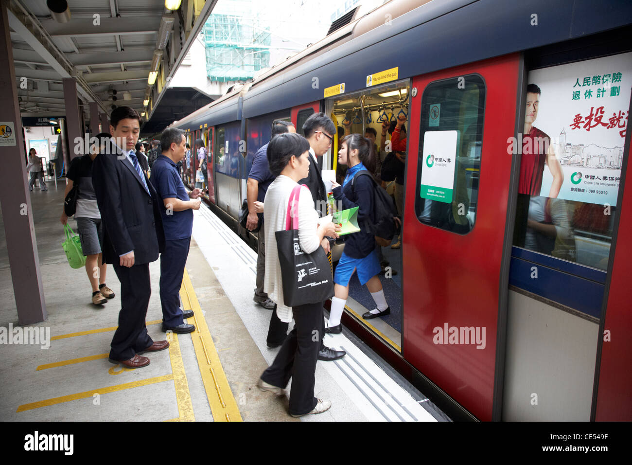 passengers boarding train at sha tin station on the mtr overground line ...