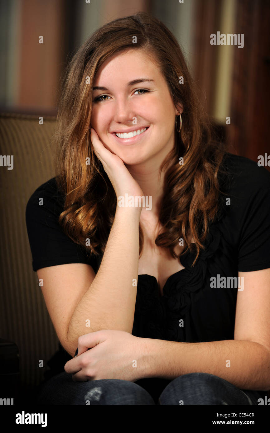 Portrait of young woman smiling with face resting on hand Stock Photo ...