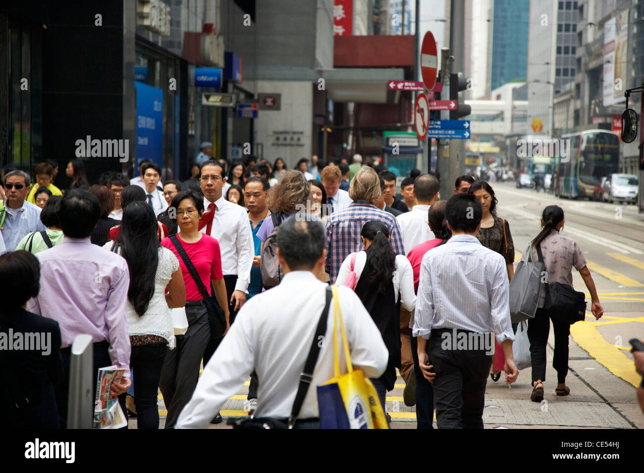 many people pedestrian crossing street road in busy downtown hong kong ...