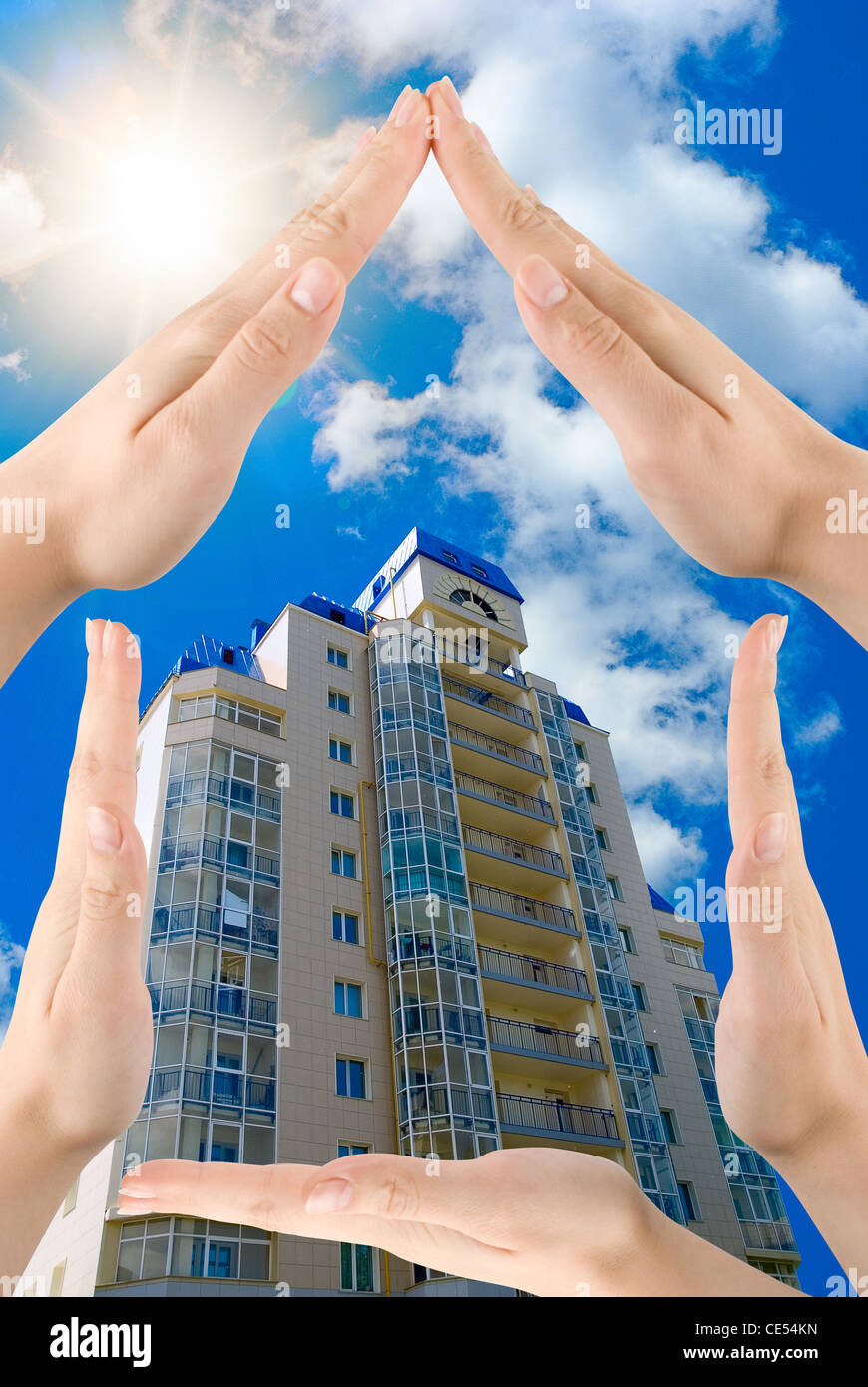 Hands showing home sign on blue modern building background Stock Photo ...