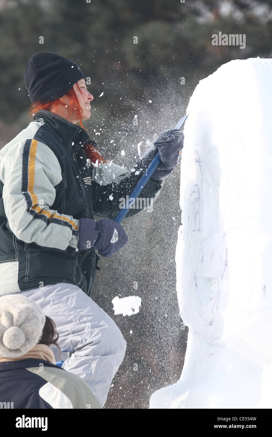 Female snow sculptor action shot chiseling snow block Stock Photo - Alamy