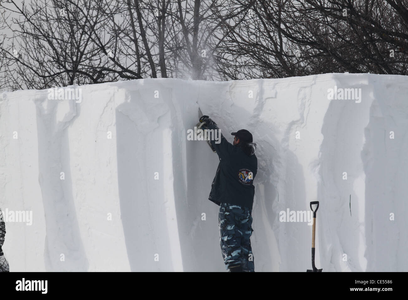 Man snow sculptor working with a power tool Stock Photo - Alamy