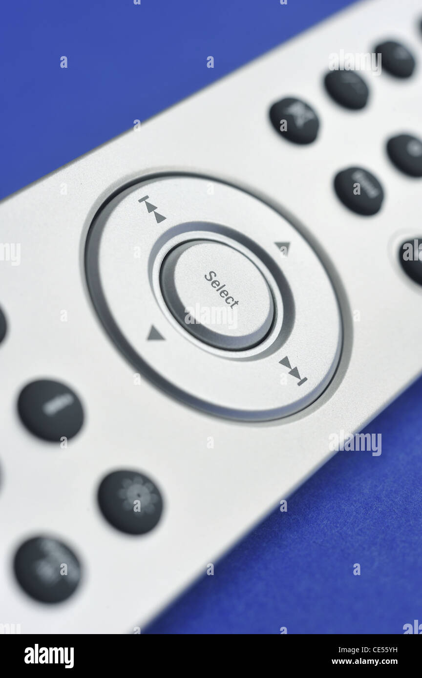 A silver coloured remote control on a blue background Stock Photo - Alamy