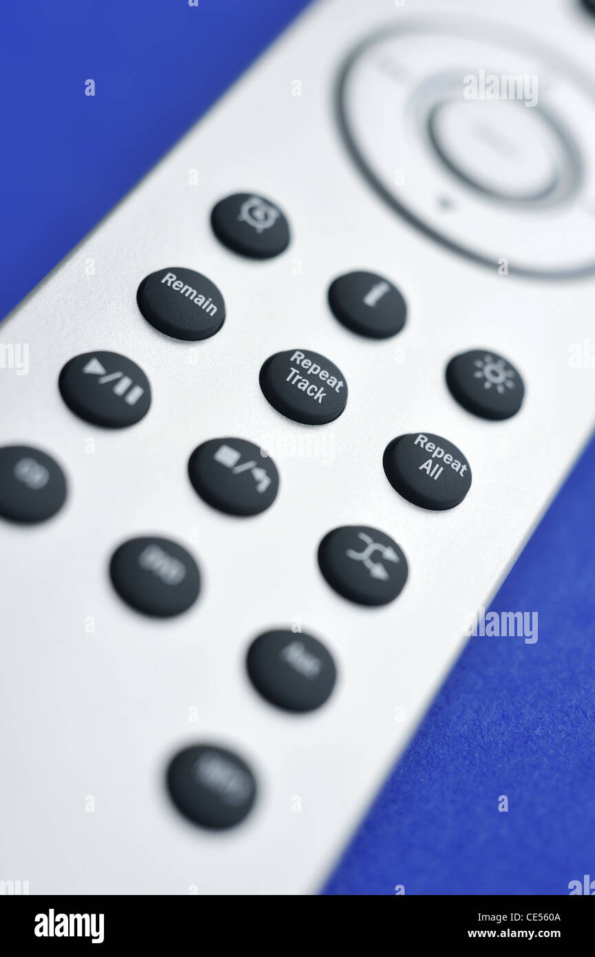 A silver coloured remote control on a blue background Stock Photo - Alamy