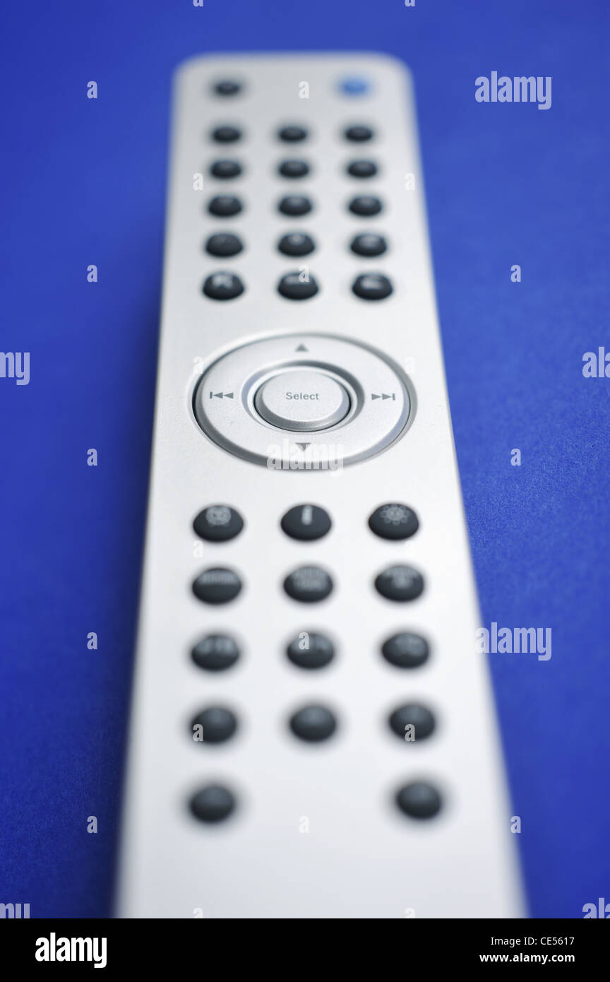 A silver coloured remote control on a blue background Stock Photo - Alamy