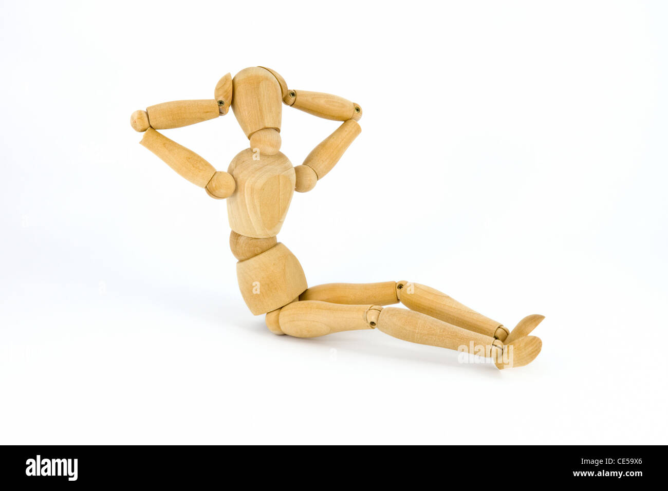 Sitting wooden toy man on a white background as a concept of press-ups ...