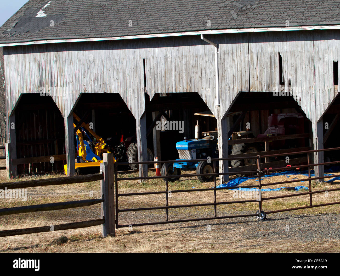 Equipment shed with a tractor and a large mower Stock Photo - Alamy