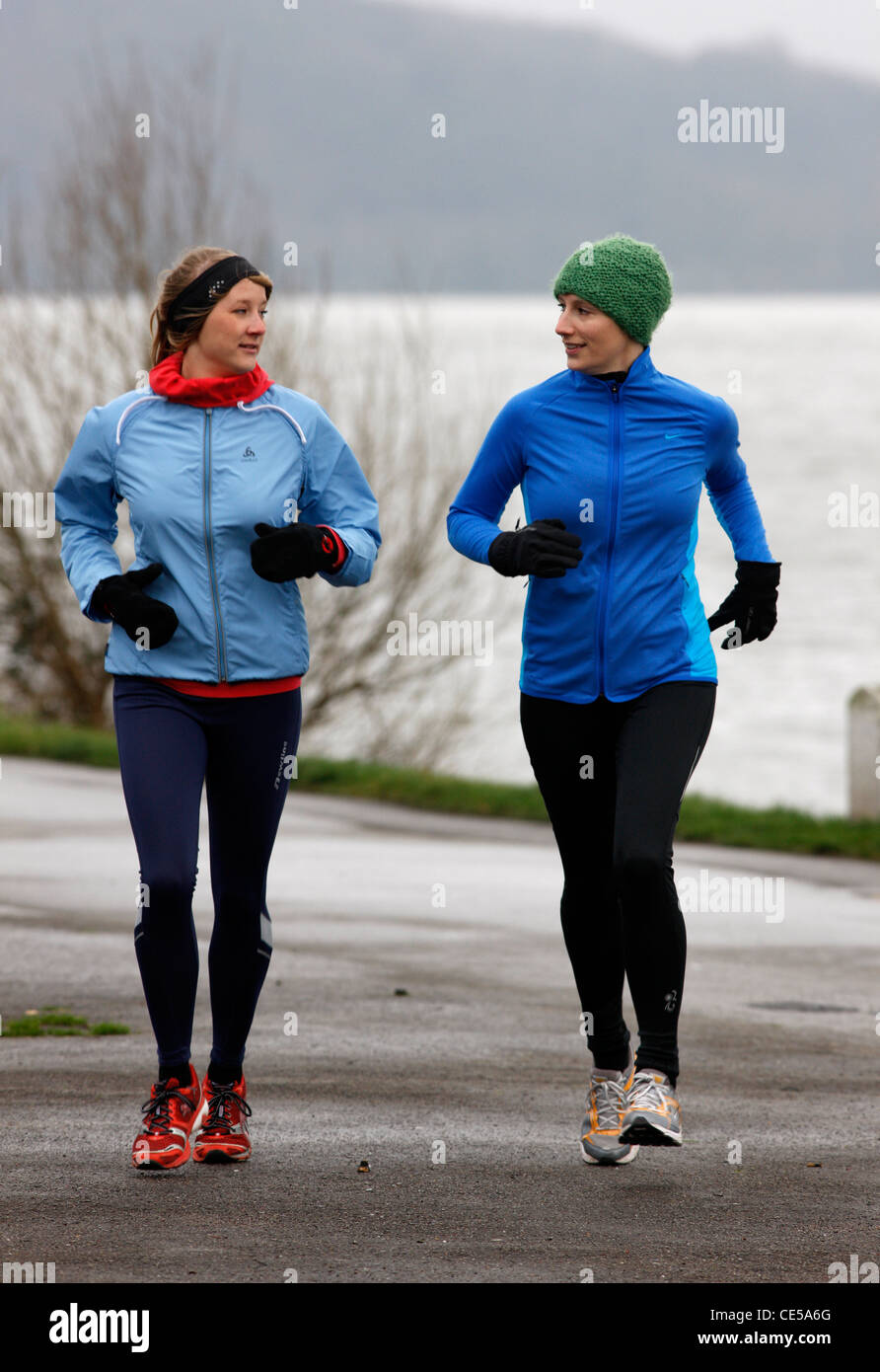 2 young women jogging in winter along a lake Stock Photo - Alamy