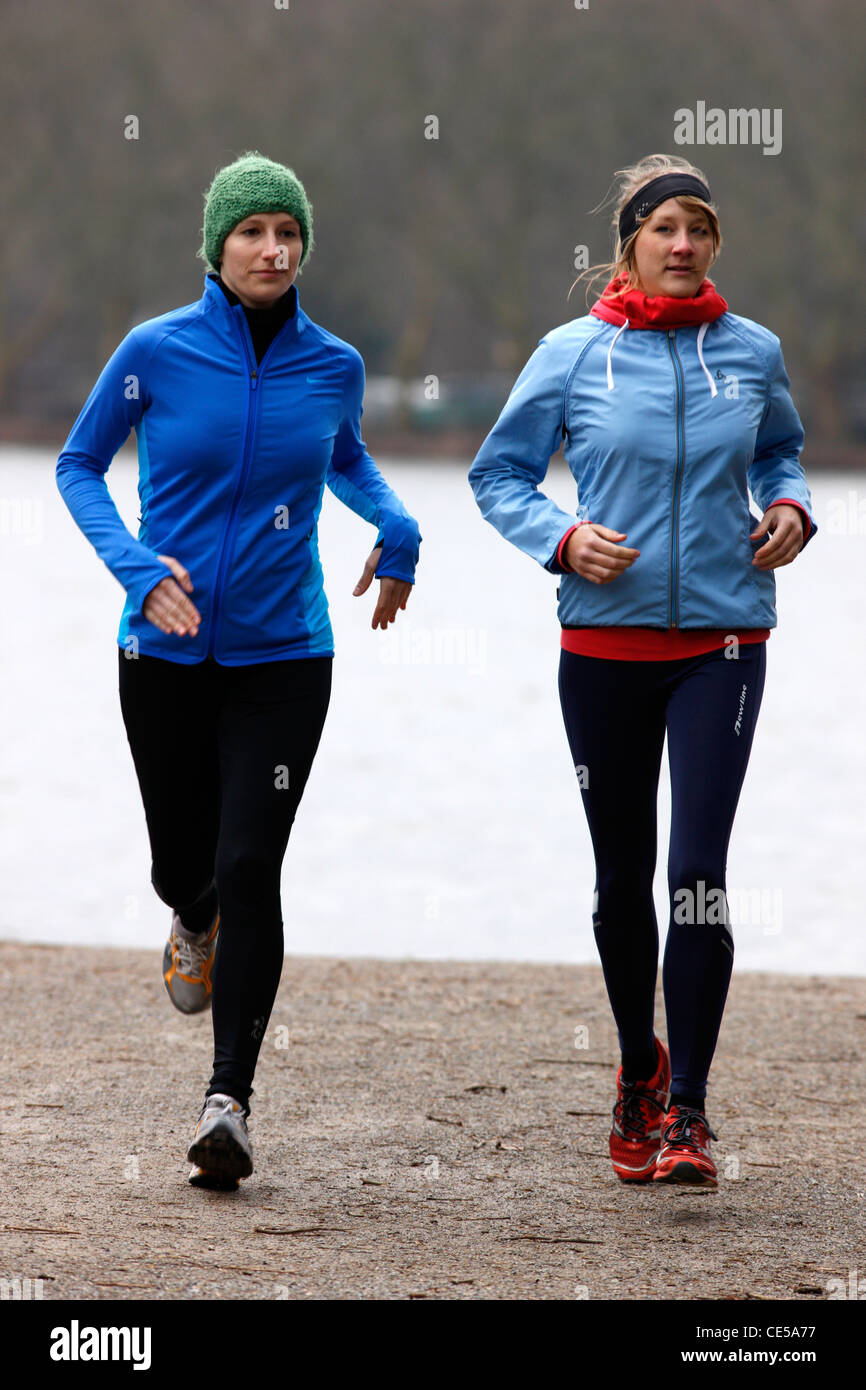 2 young women jogging in winter along a lake Stock Photo - Alamy