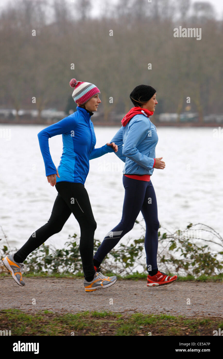 2 young women jogging in winter along a lake Stock Photo - Alamy