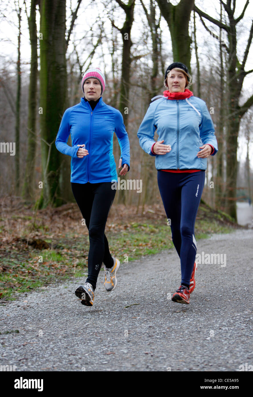 2 young women jogging in winter, in a forest Stock Photo - Alamy