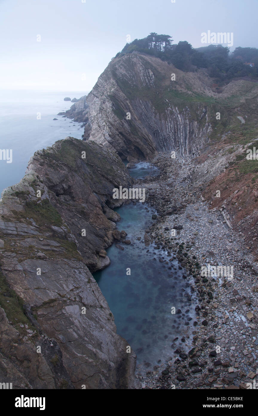 Looking down from the clifftop into Stair Hole. The tilted rock strata ...