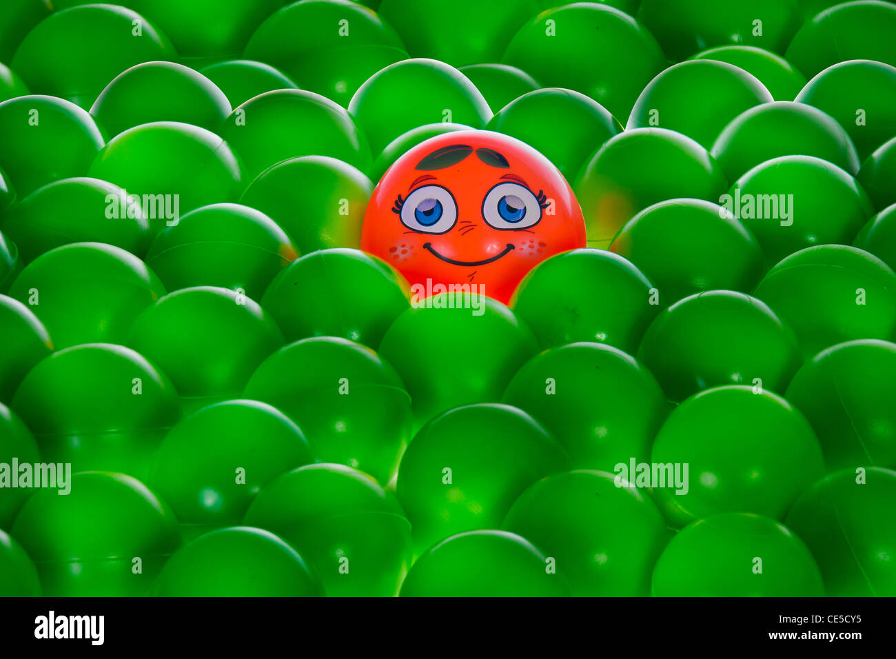 an orange happy ball with big blue eyes and two leafs in middle of ...