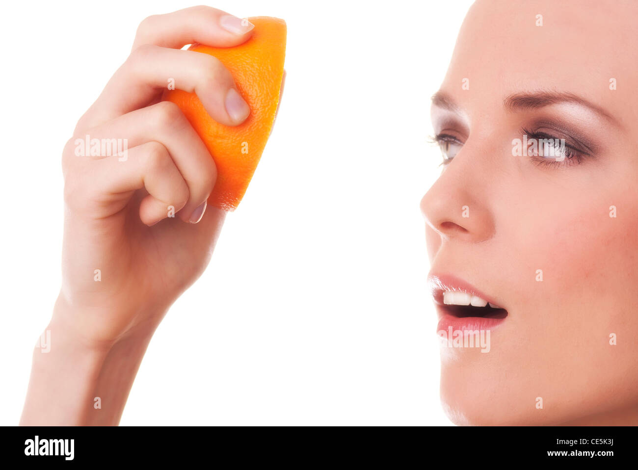 woman squeezing an orange onto her face Stock Photo - Alamy