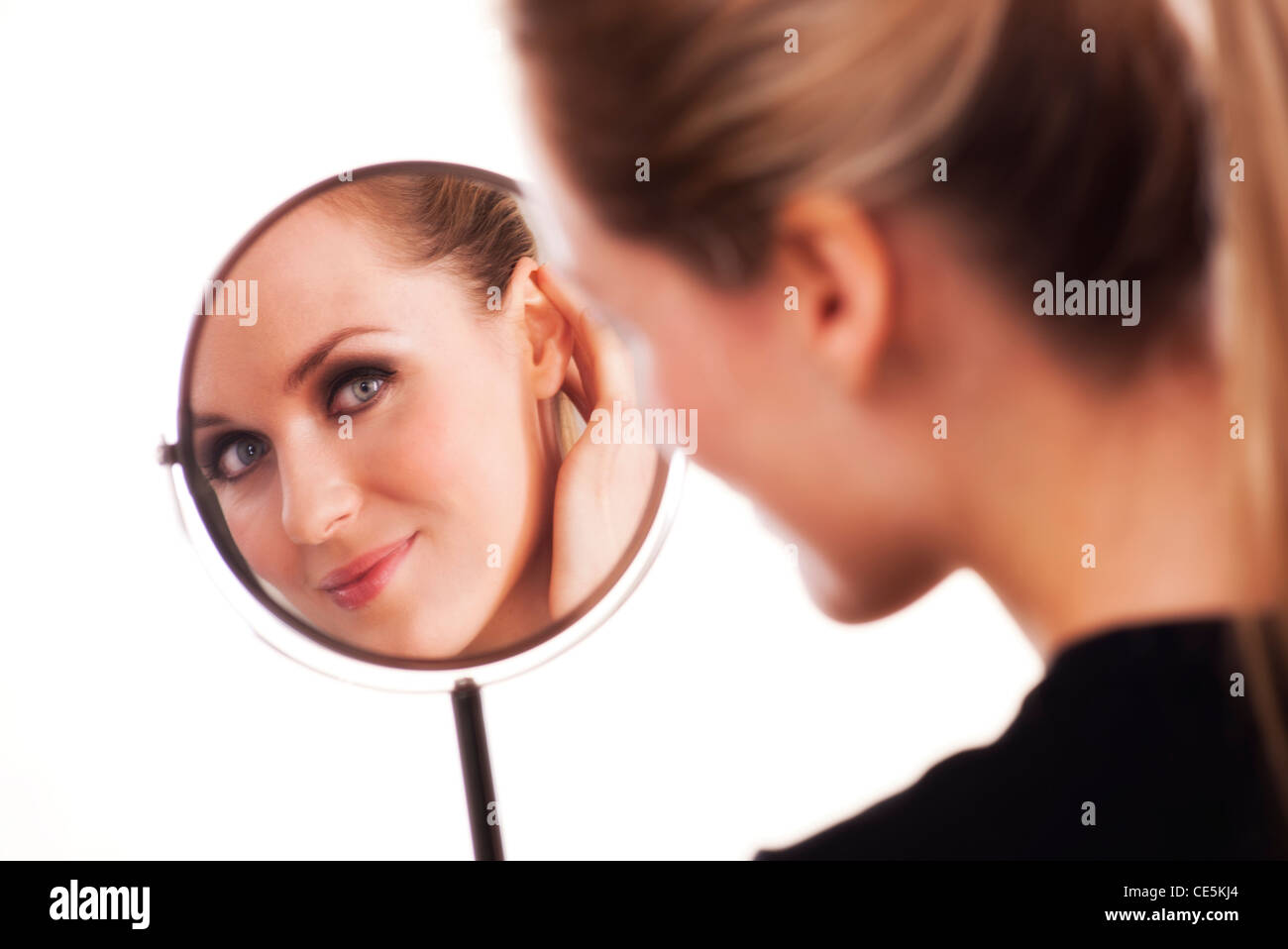 woman looking into a mirror Stock Photo - Alamy
