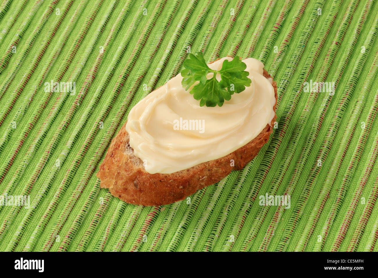 Slice of bread roll and creamy cheese spread Stock Photo - Alamy