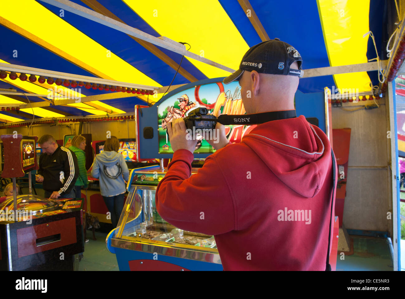 Man taking a photograph inside a tent / marquee at a fair filled with ...