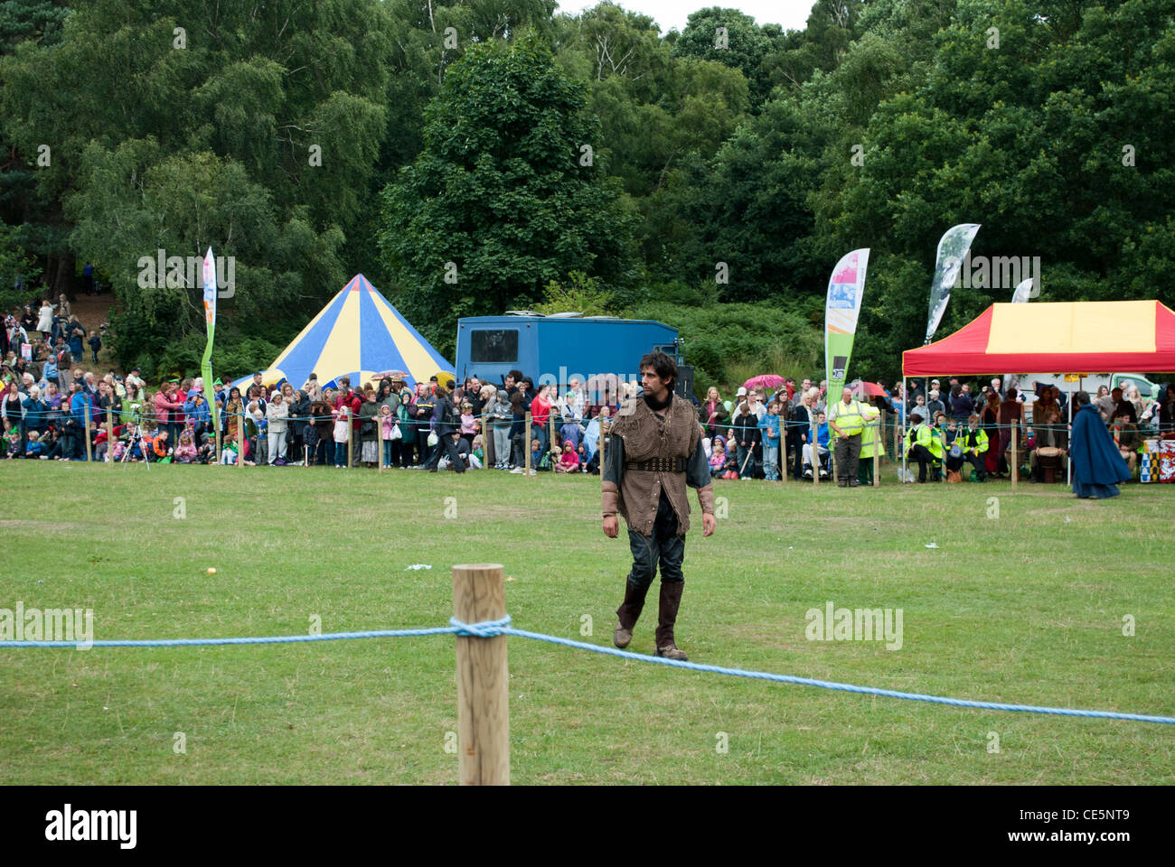 Man in medieval costume s at jousting tournament with crowd and ...