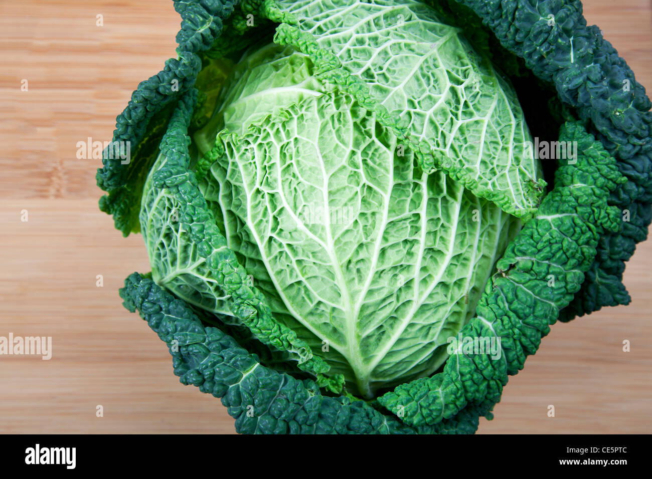 Head of curly green leaf cabbage on cutting board. Angle of view from ...