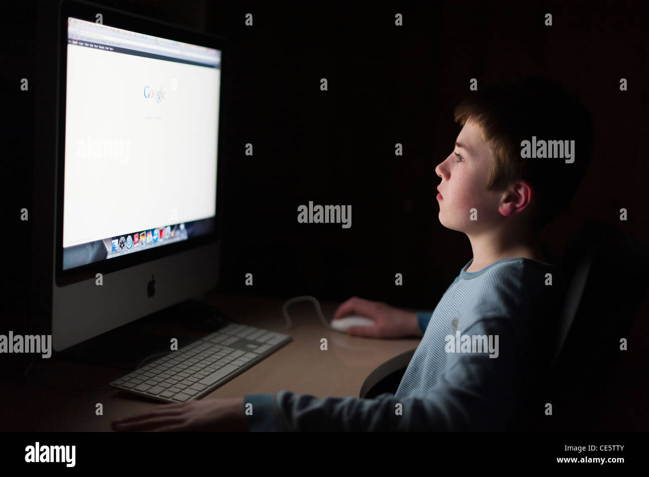 A 12 year old boy on his apple imac computer on Google internet website ...