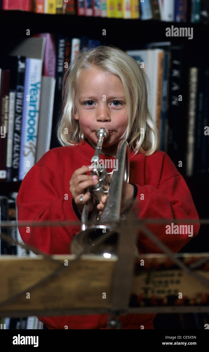 Girl age 6 playing cornet in front of music stand Stock Photo - Alamy
