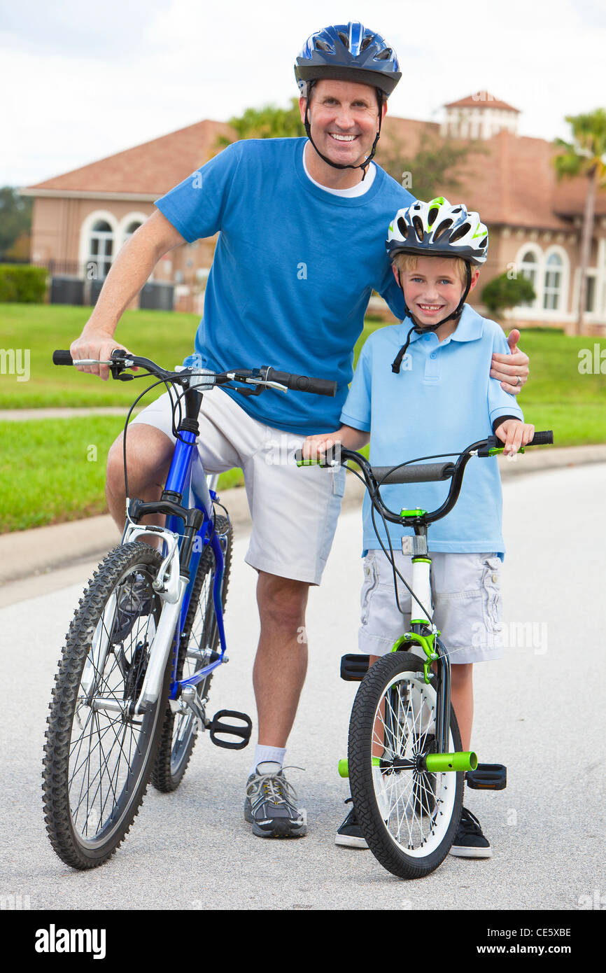 A young family of man and boy, father and one boy child, cycling ...