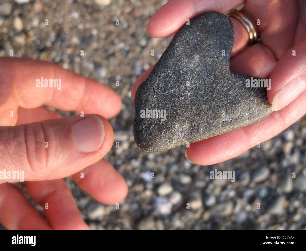 Woman giving heart rock to man Stock Photo - Alamy