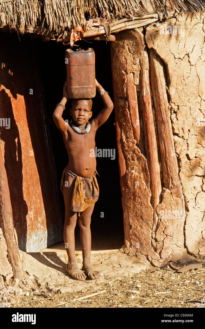 Young Himba girl carrying water in village near Opuwo, Namibia Stock ...