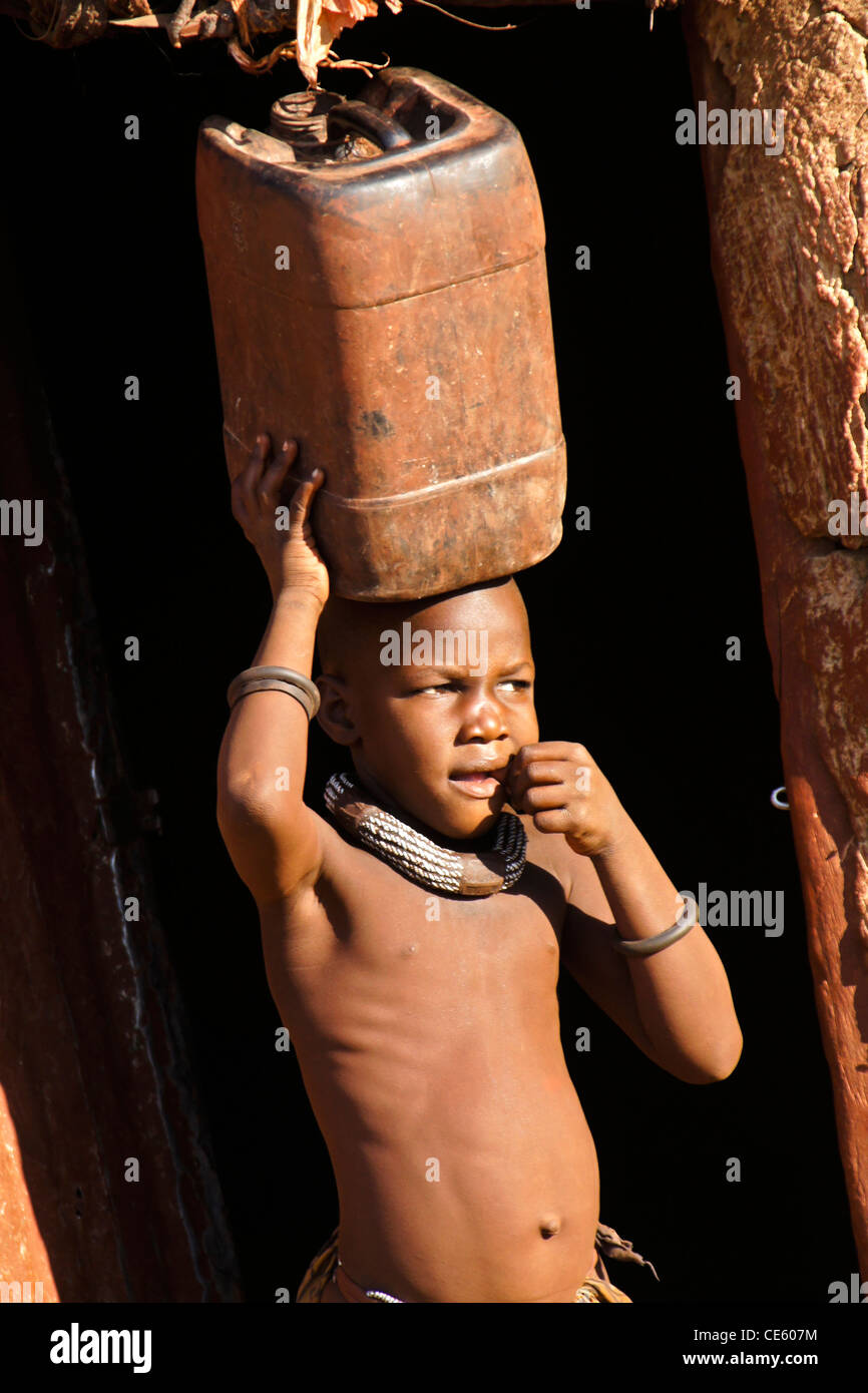 Young Himba girl carrying water in village near Opuwo, Namibia Stock ...
