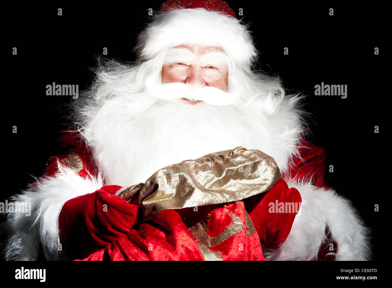 Santa sitting at the Christmas room and looking into the sack Stock ...