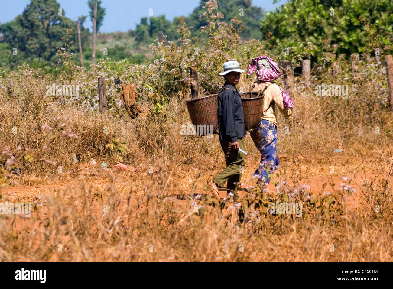 A man and a woman who are farmers are walking in a typical rural farm ...