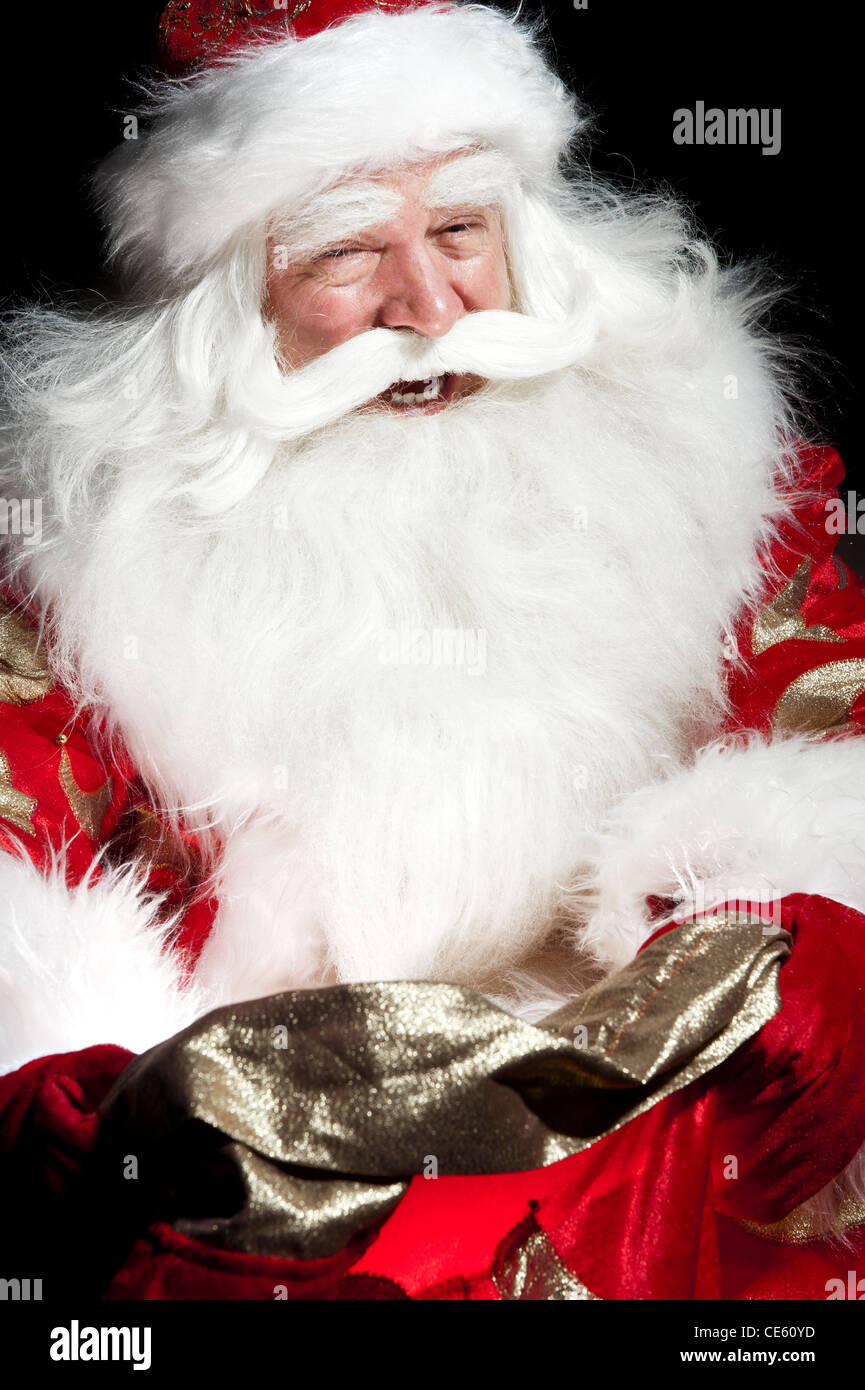 Santa sitting at the Christmas room and looking into the sack Stock ...