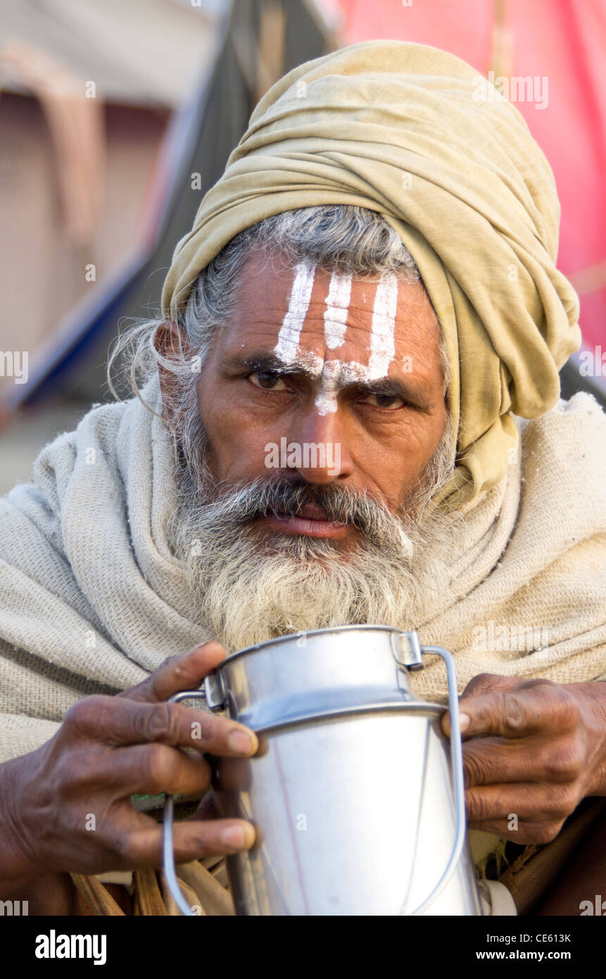 a hindu bearded pilgrim at Sangam with Shaivite tilak drinking milk ...