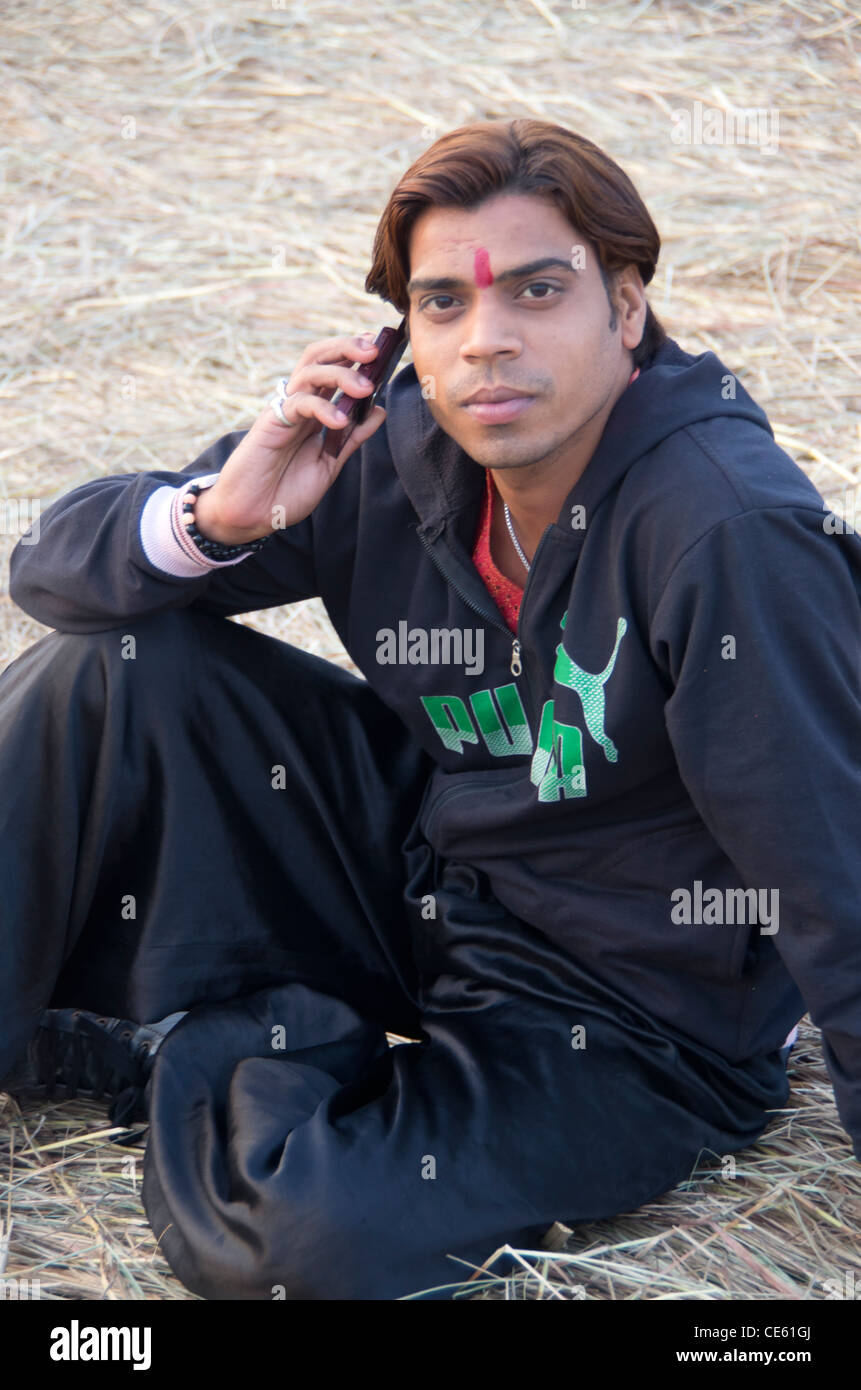 a young confident Indian clean-shaven man in a track suit, tilak, and a ...