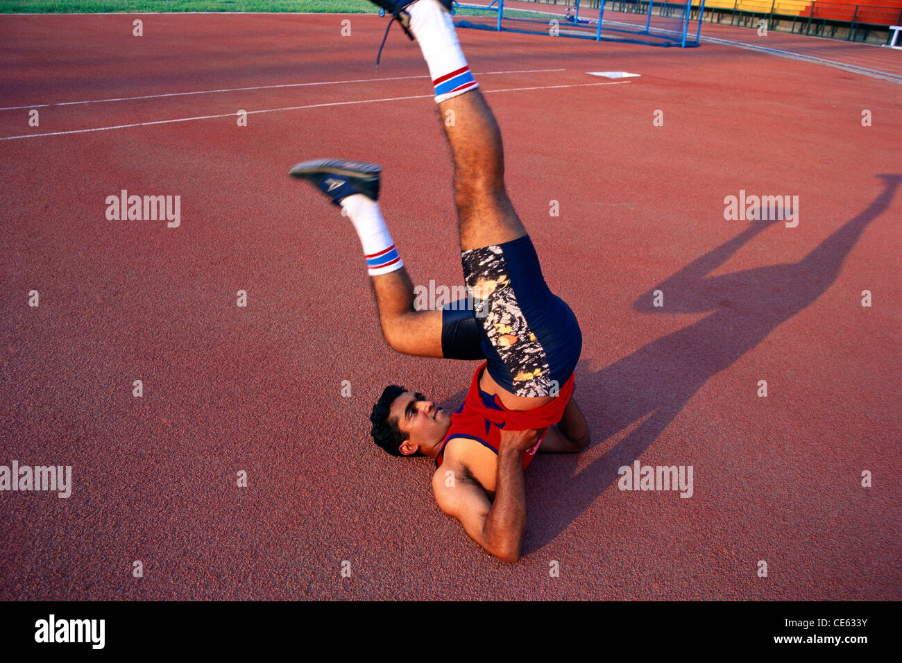Indian teenager boy athlete runner exercising before start of race ...