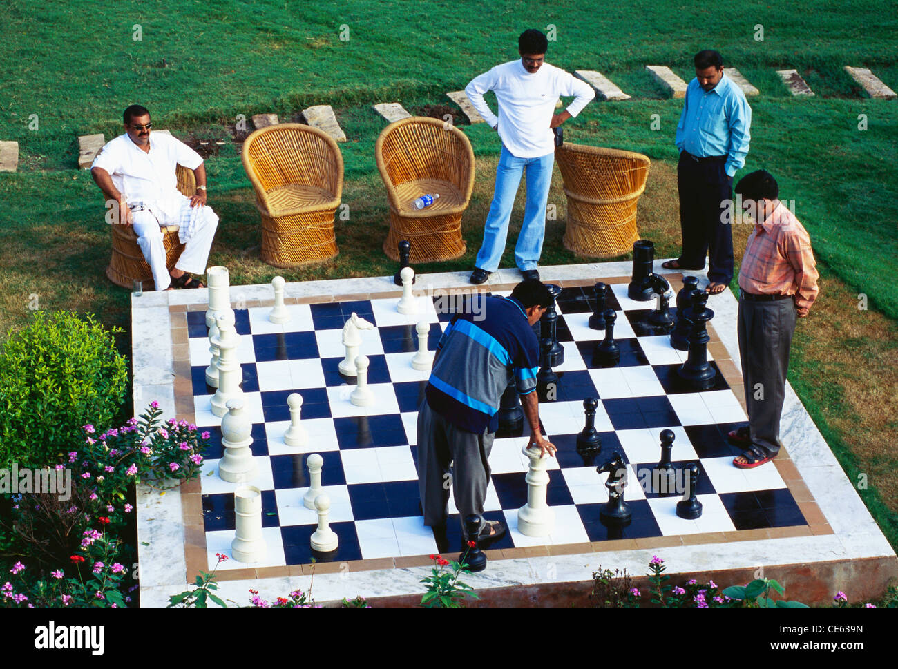 Indian men playing chess on big man size chess board ; Rajasthan ...