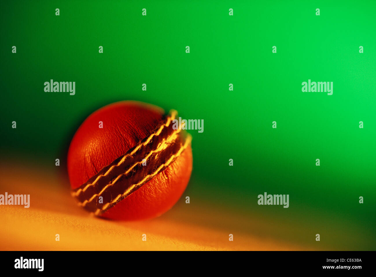 Cricket ball on green background Stock Photo - Alamy