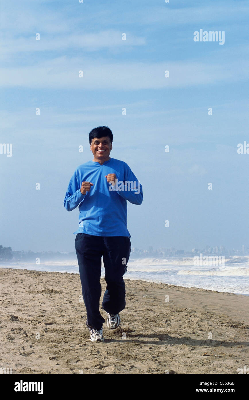 Indian senior man jogging on beach ; India ; Asia ; MR#448 Stock Photo ...