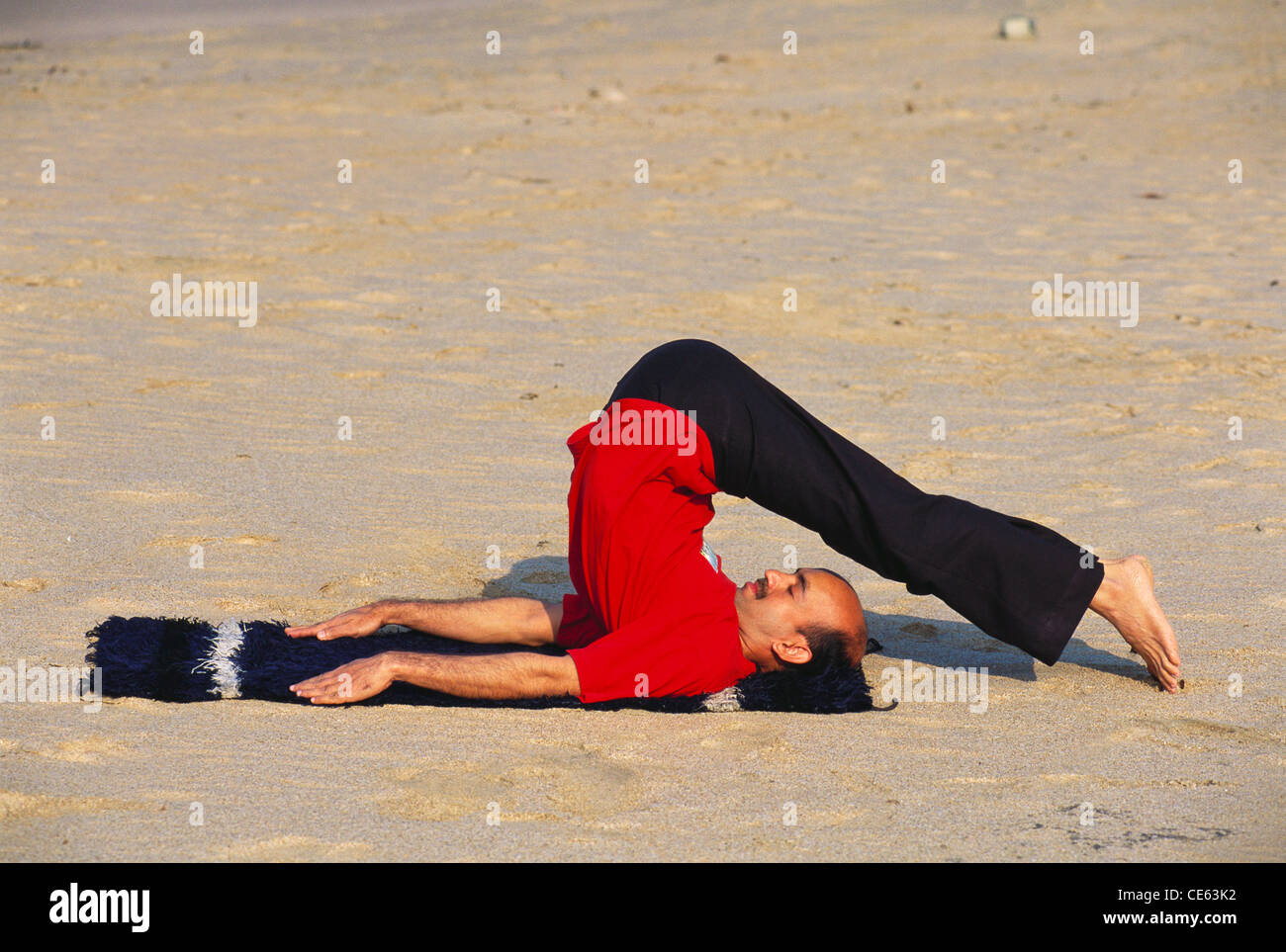 Indian man showing yoga exercise posture Halasana ; Halasan ; Plough ...