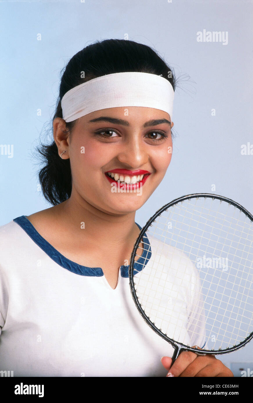 Indian woman tennis player in headband sweatband with tennis racket ...