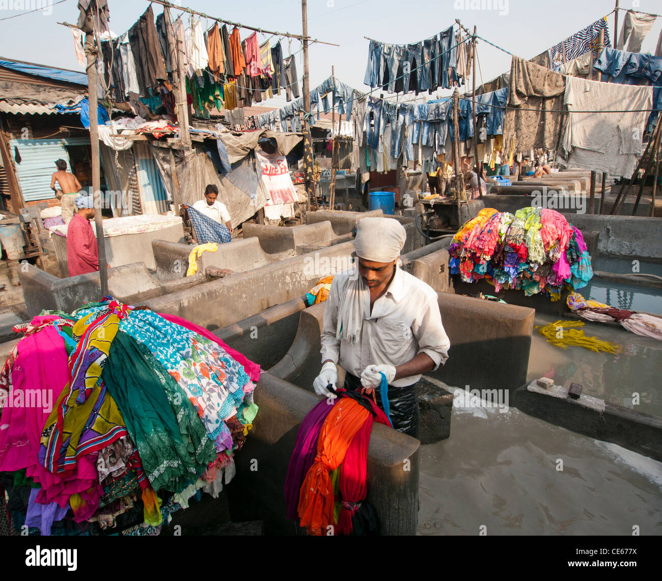 A Dhobi Wallah washing clothes at the Dhobi Ghat which is a large open ...