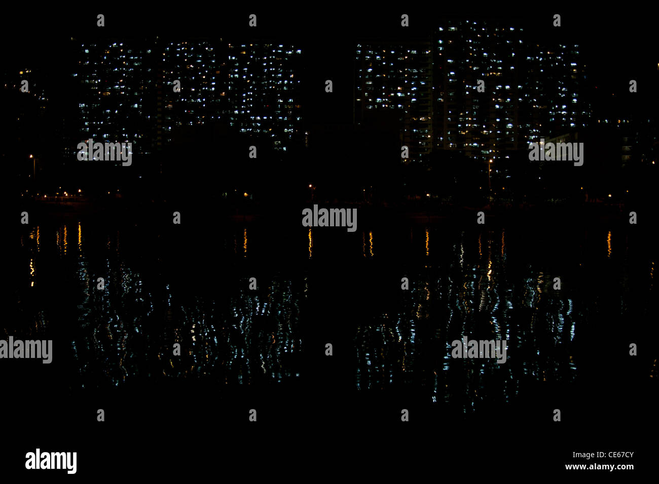 Lights of tower blocks and city lights at night reflected in the Shing ...