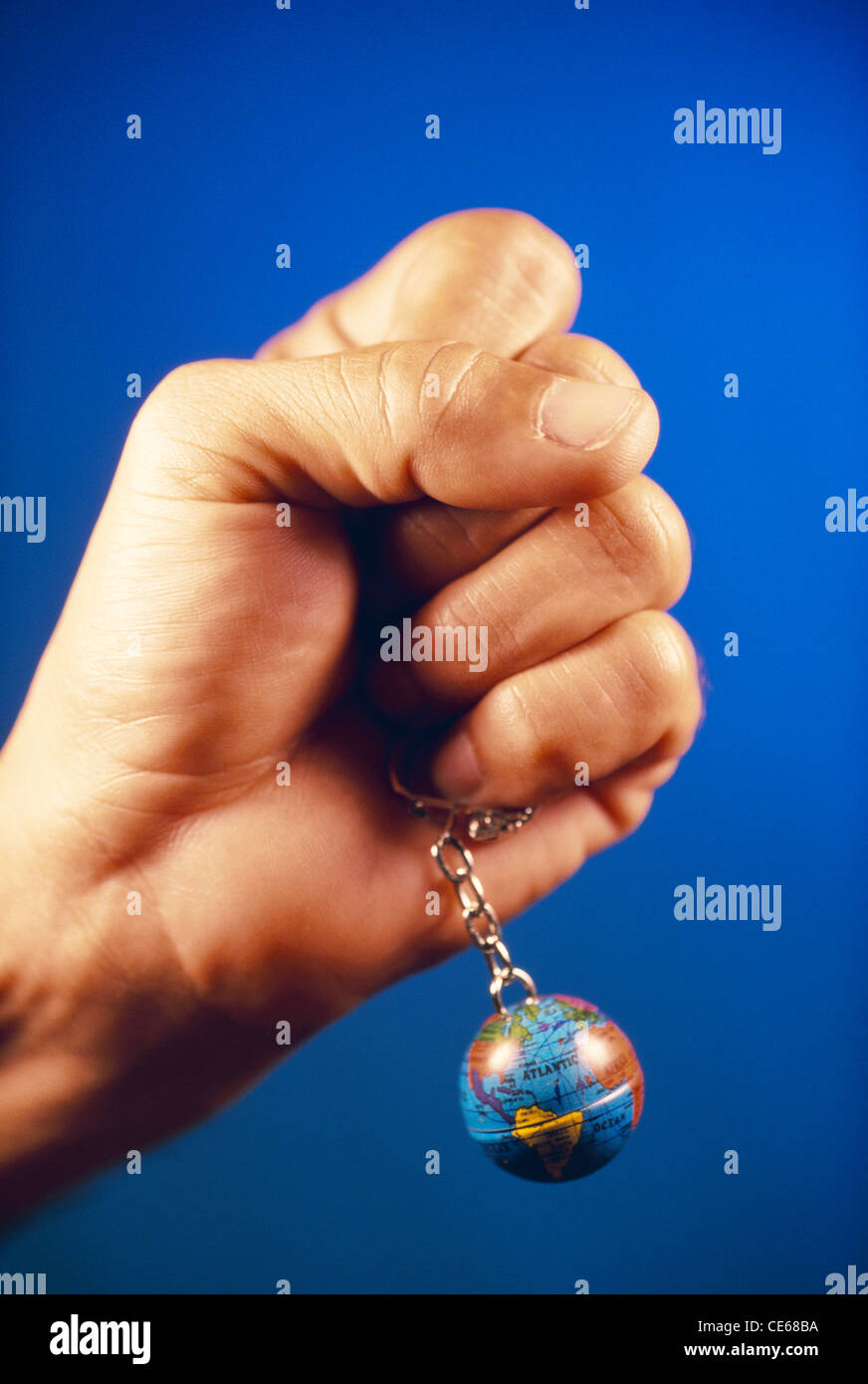 Concept ; hand holding globe world earth key chain ; human control ...