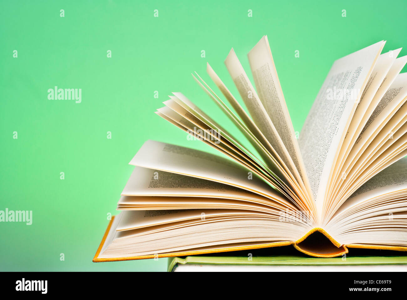 An open book on a pile of other books books Stock Photo - Alamy