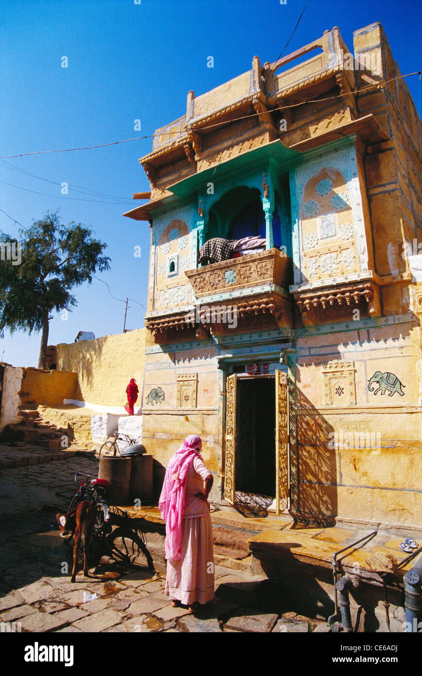 Indian rural woman standing in front of her small house ; small town ...